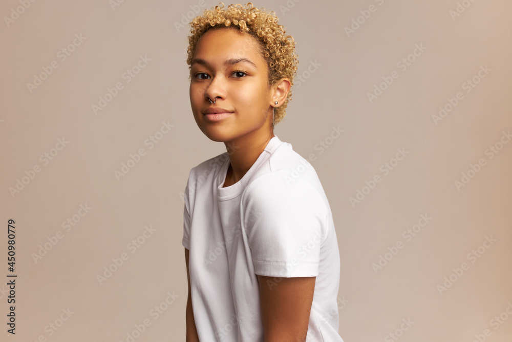 Studio shot of attractive young lady of mixed-race posing with calm ...