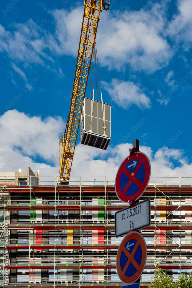 Crane lifting a wooden building module to its position in the structure ...