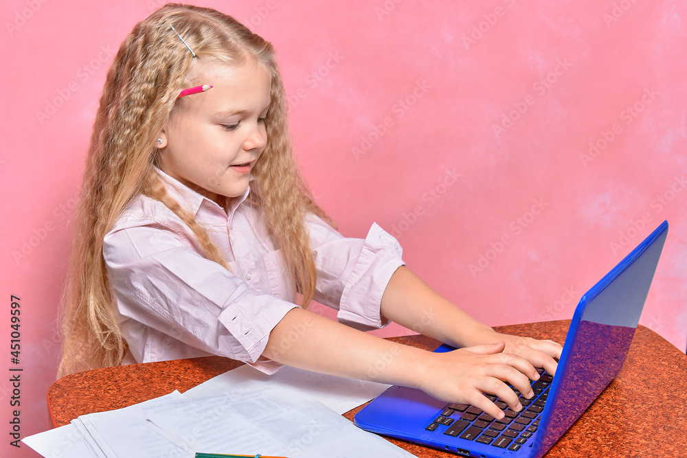 little girl is typing at the laptop. online learning Stock Photo ...