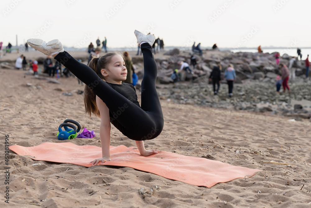 Girl gymnast trains on the beach by the sea. Photo series Stock Photo ...