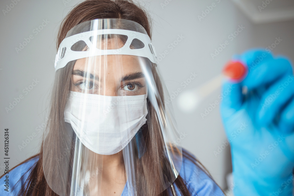 Female caucasian doctor holding a swab collection stick, nasal and oral ...