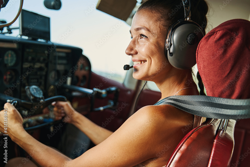 Positive delighted female person flying the plane Stock Photo | Adobe Stock