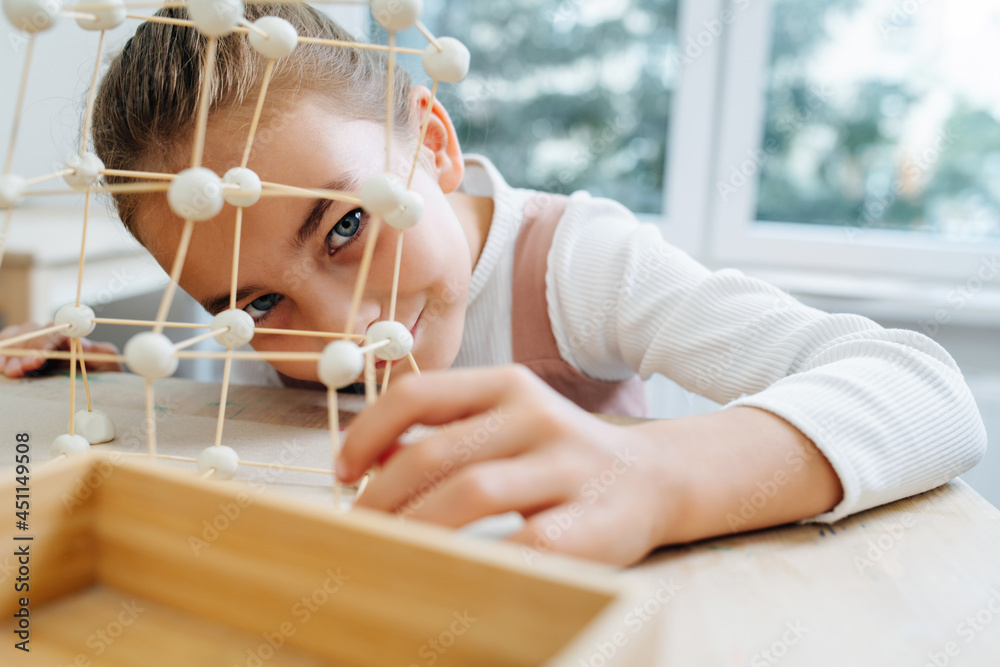 Rapt little girl is busy building 3d shapes from plasticine and ...