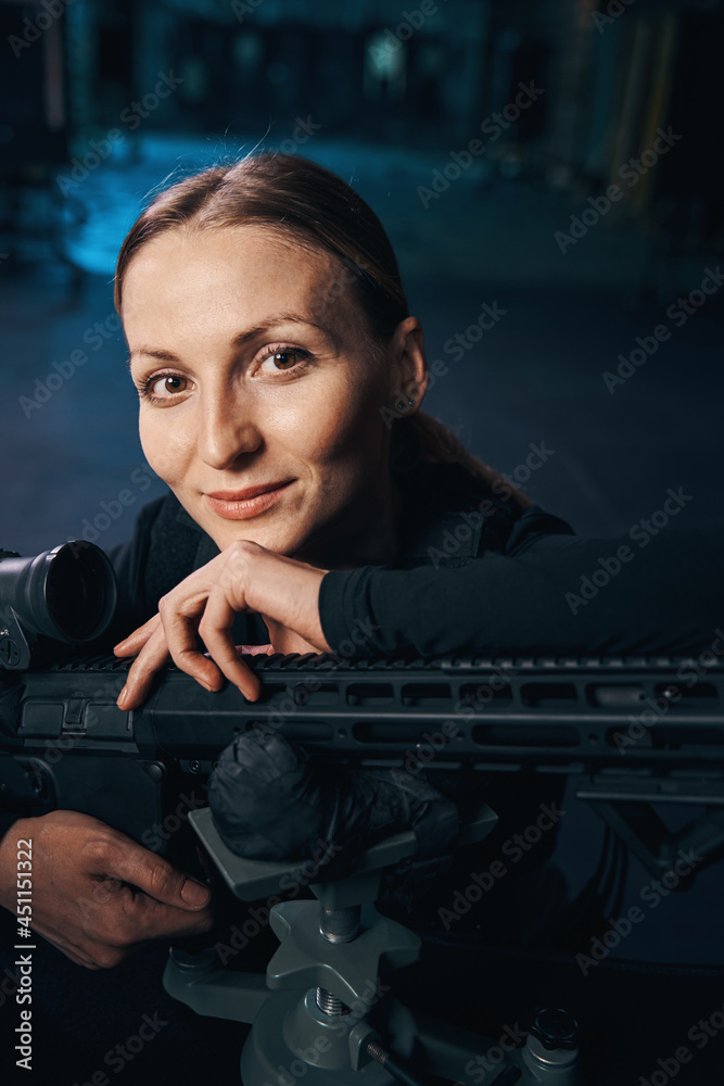 Contented woman sniper posing for the camera with her machine gun Stock ...
