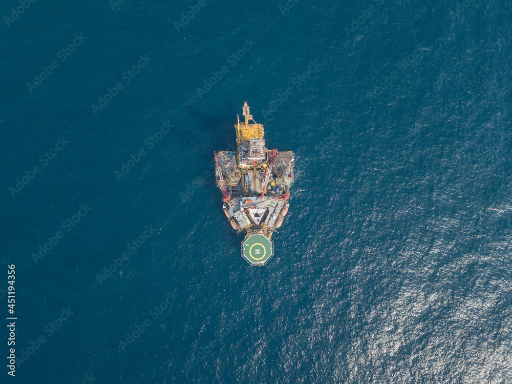 Offshore drilling rig (jack up rig) and tow vessels during the rig move operation in the middle ...
