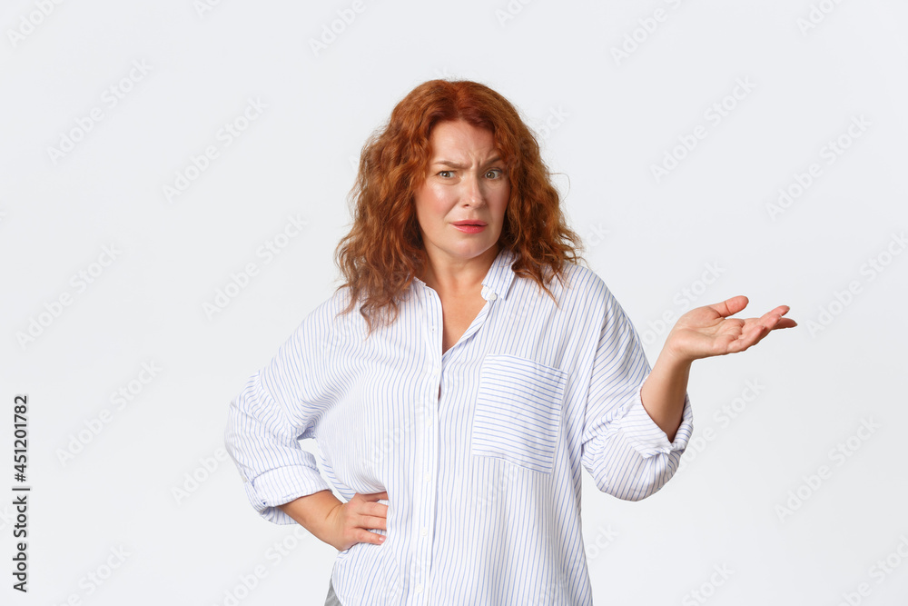 Frustrated and confused middle-aged redhead woman complaining, raise ...