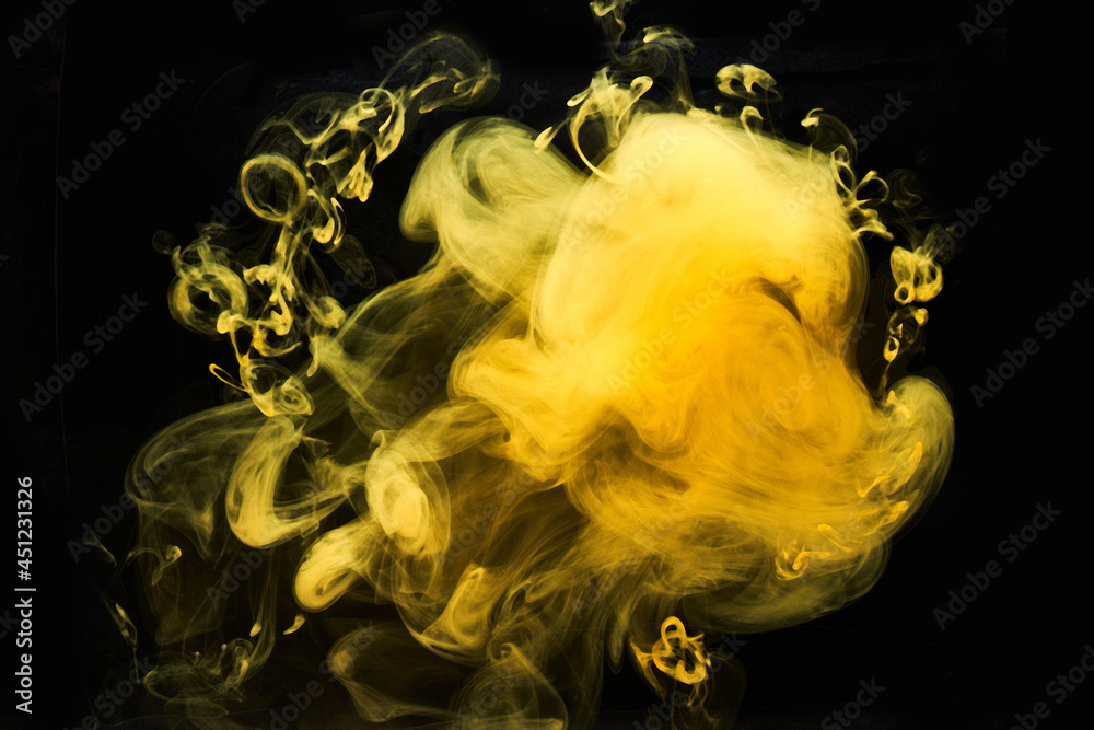 Abstract liquid art, yellow smoke bomb on black background, amber color ...
