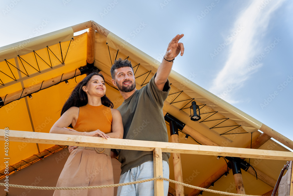 Young man pointing forwards while showing place of interest to his wife ...