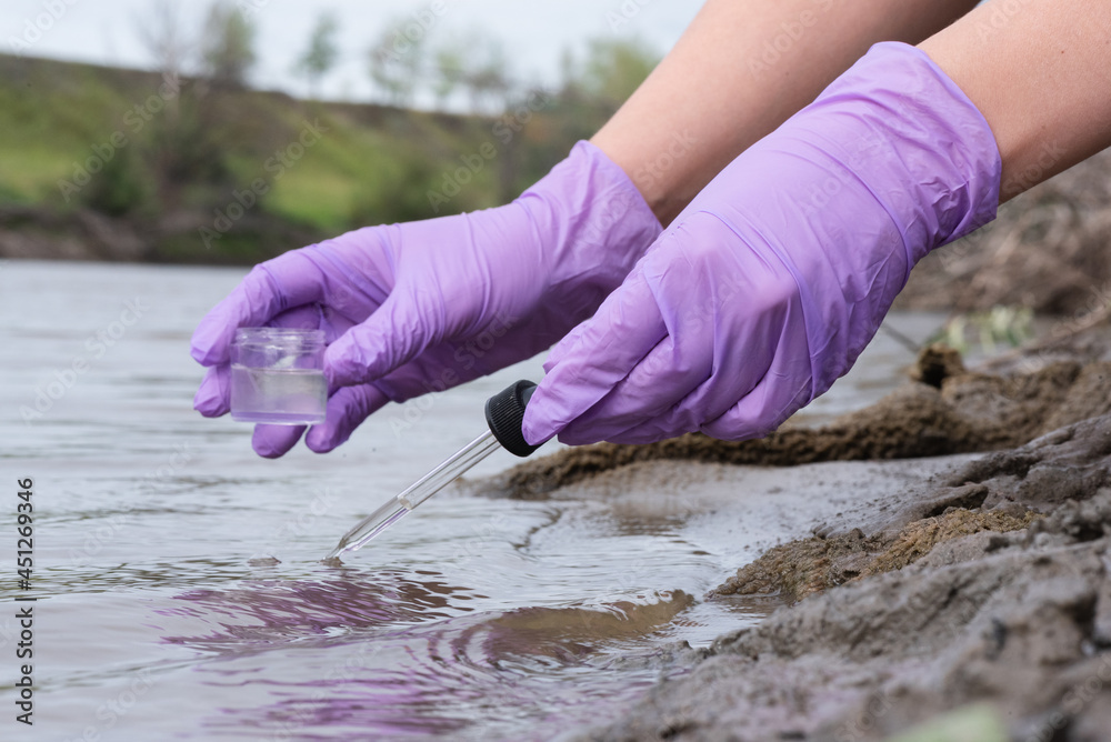 Water pollution concept. Woman a scientist takes a water sample from a ...