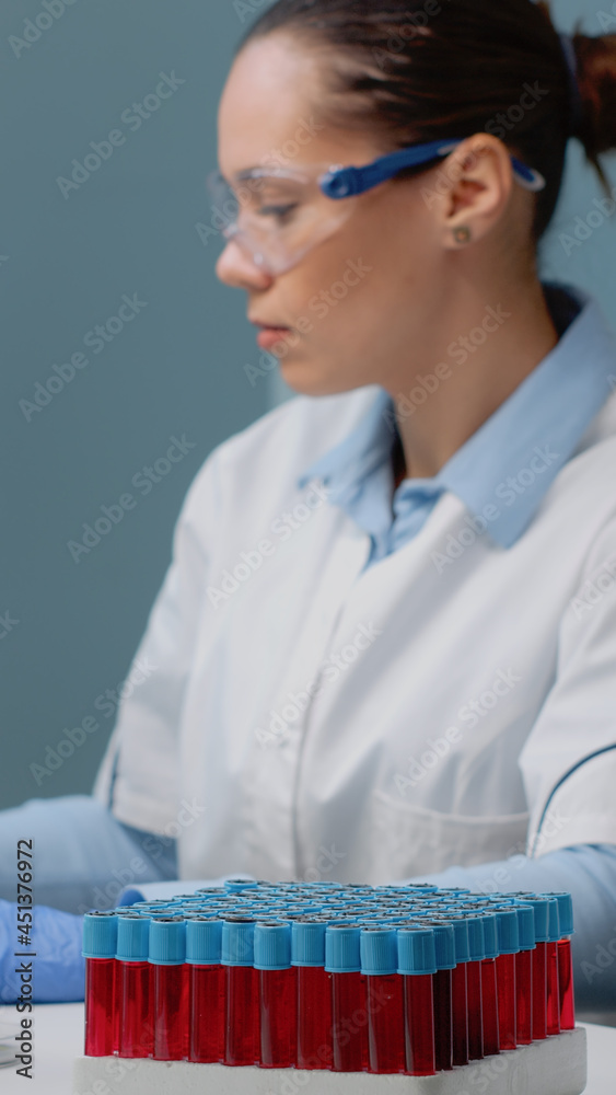 Microbiology specialist using computer in laboratory while having ...