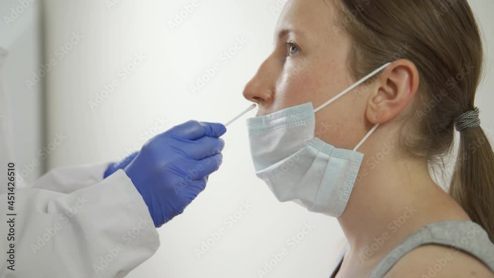 Coronavirus test. The patient lowers the medical mask and the doctor ...