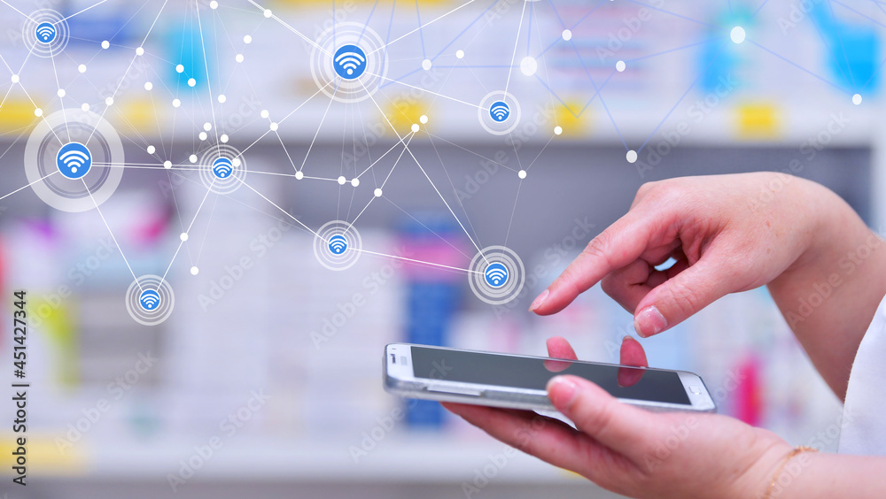 Pharmacist using a smart phone for filling prescription in pharmacy ...