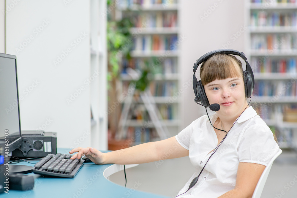 Young girl with syndrome down uses computer at home. Education for ...