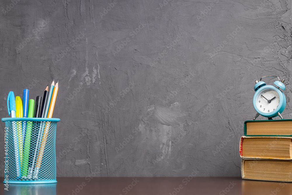 back to school concept. desk with stationery supply over concrete wall ...