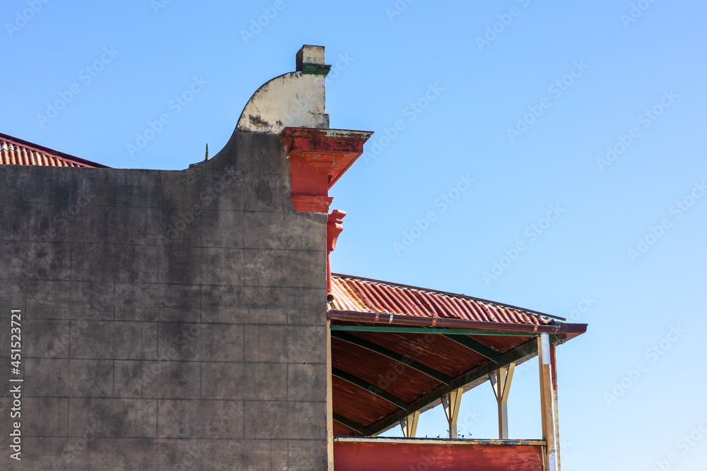 View of an old block wall and dilapidated verandah with rusted ...