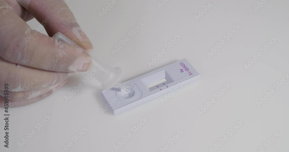Closeup shot of doctor hand pressing drop test of liquid antigen to ...