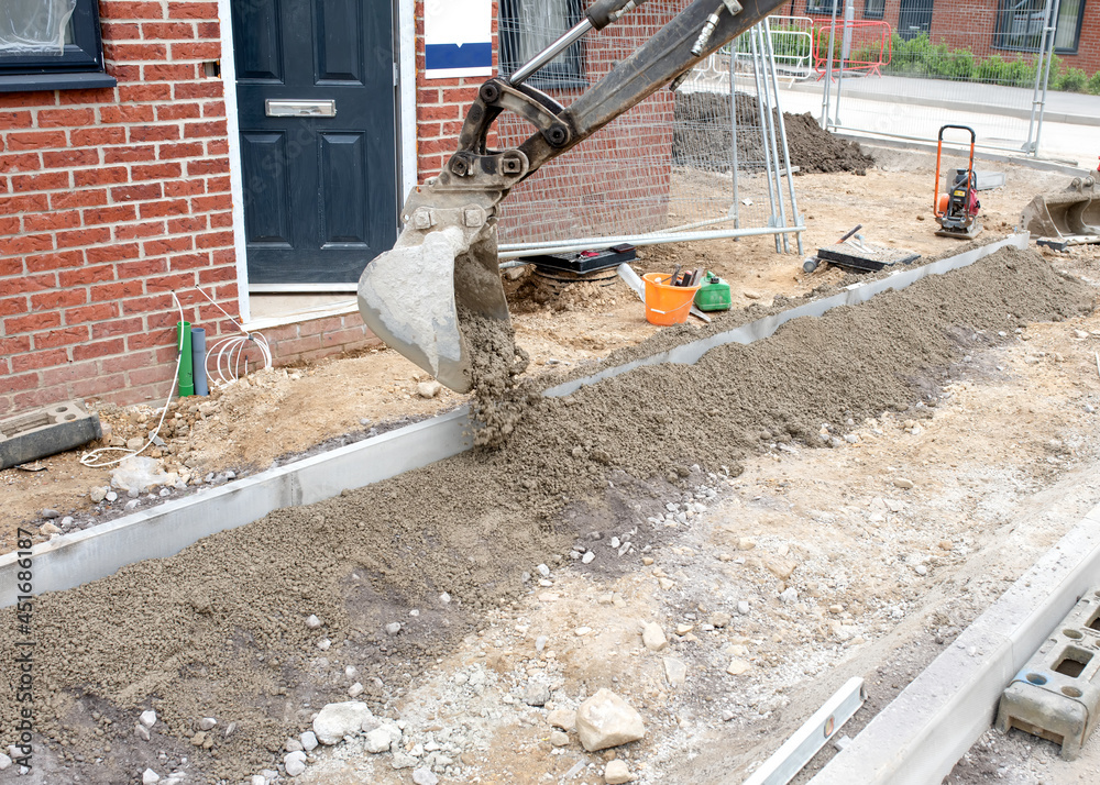 Installation of edging kerb during footpath construction in front of ...