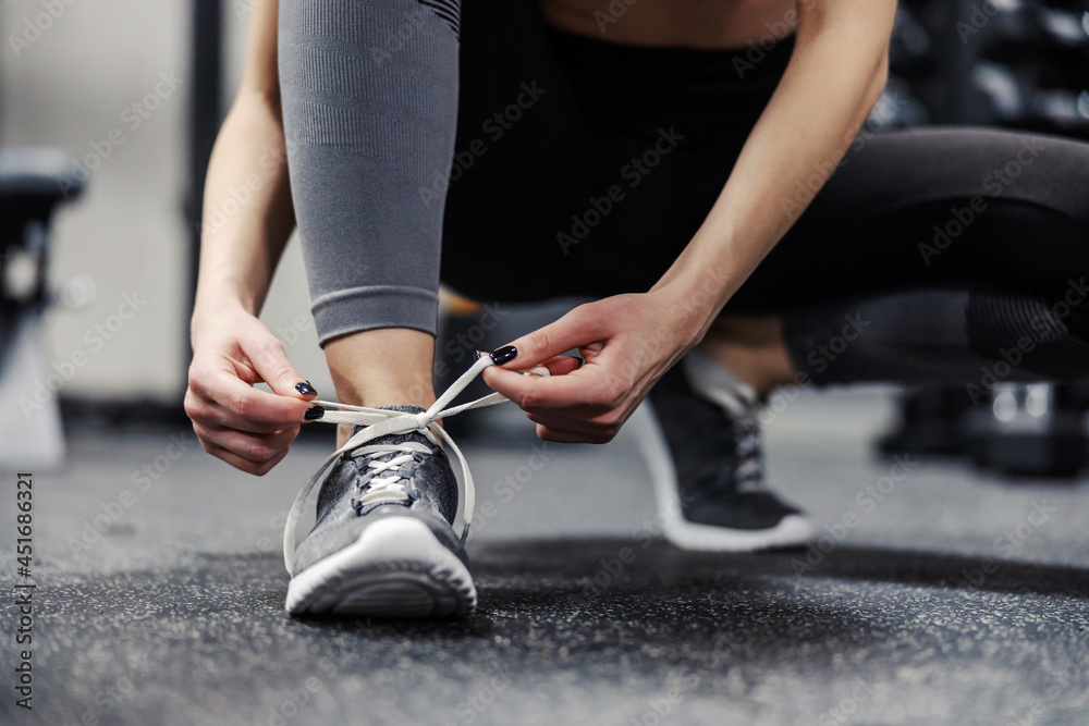 Preparing for exercise. Tying shoelaces on sneakers before training ...