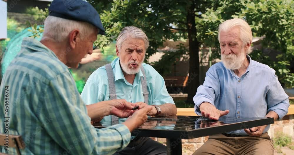 Waist up portrait view of the cheerful caucasian old men playing a ...