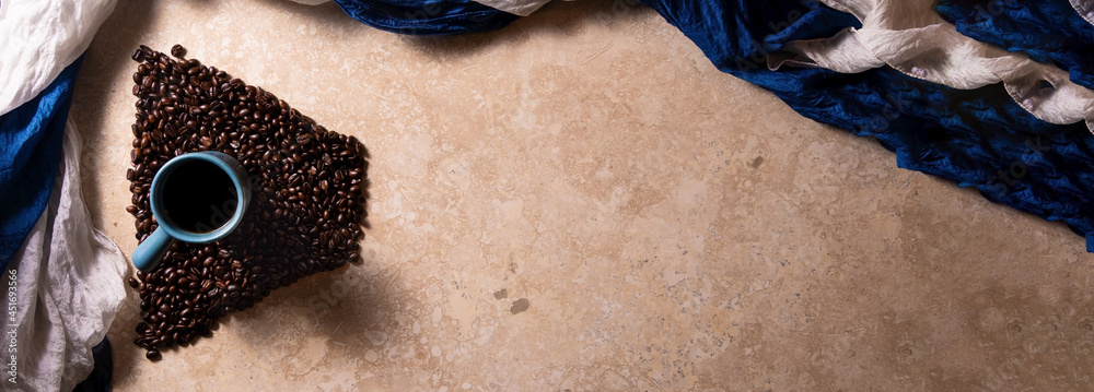 taza de café azul sobre granos de café en fondo de mármol con telas ...