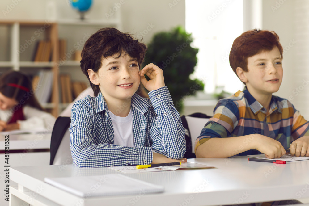 Young child in class. Smiling little boy sitting at desk in classroom ...
