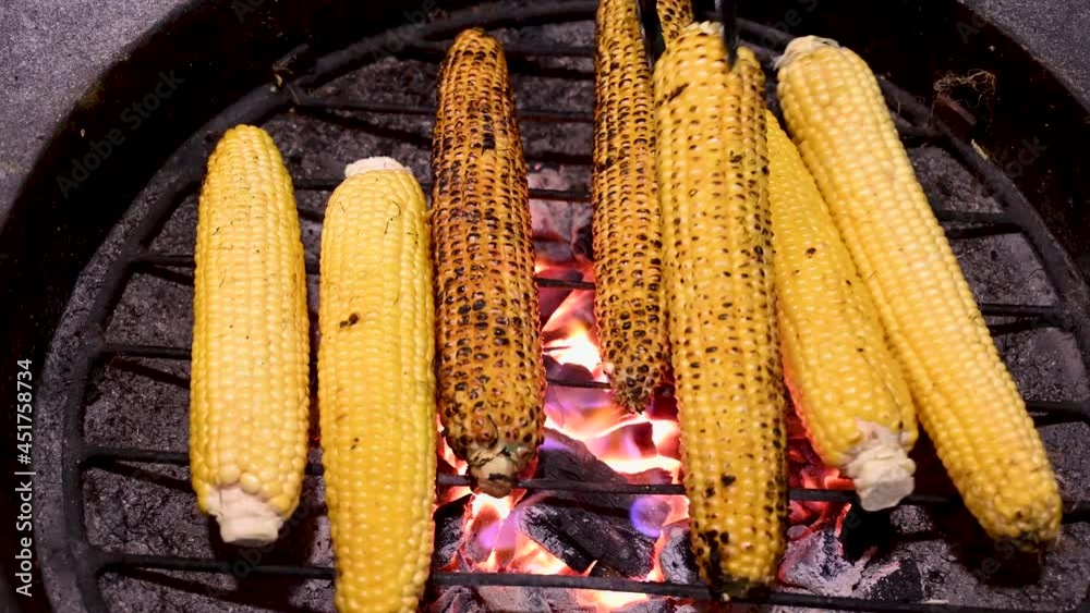 Grilled corn on the cob on the hot grill. Grilled and roasted Corn on ...