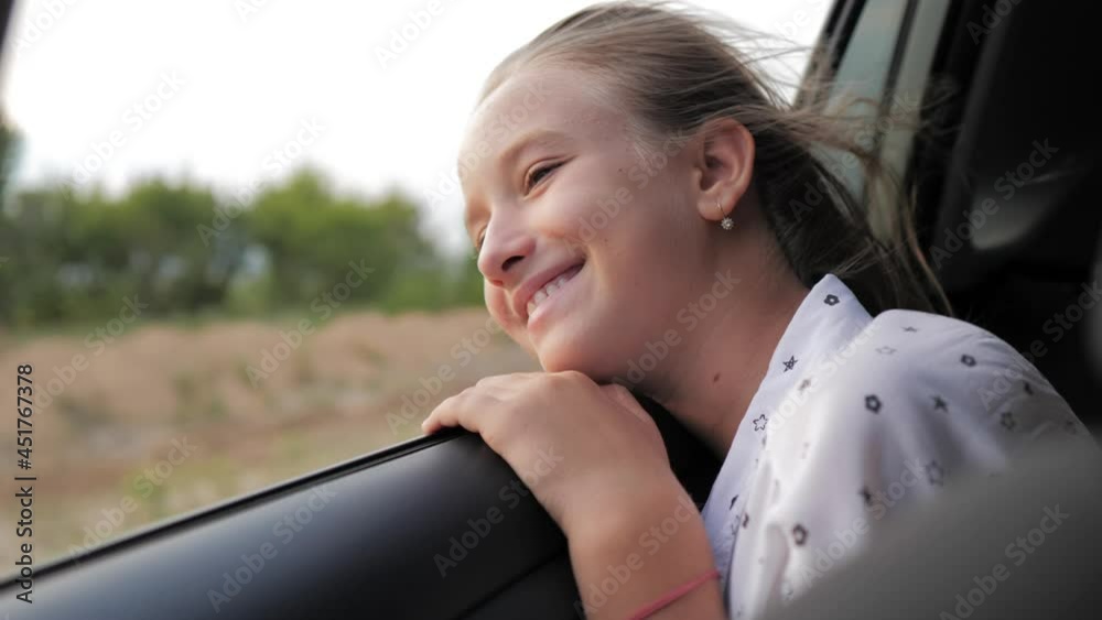 Happy family travel. Little girl leaning out of car window waving hand ...