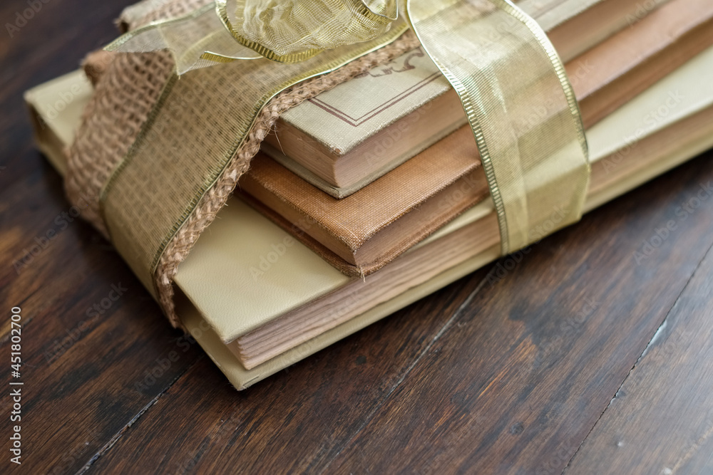 Well read and worn out books wrapped with a hemp and gold ribbon on an ...