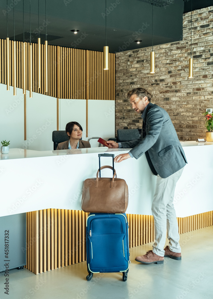 Handsome Business Man Checking In at Hotel. Businessman with passport ...