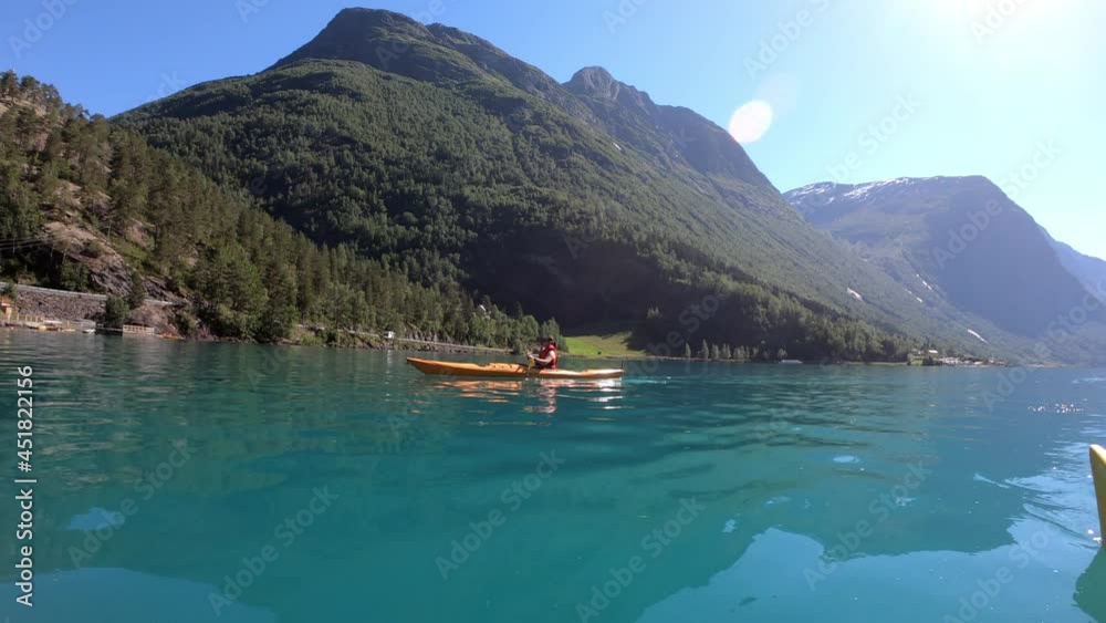 Brunette paddling kayak through glacial lake Lovatnet norway - Bright ...