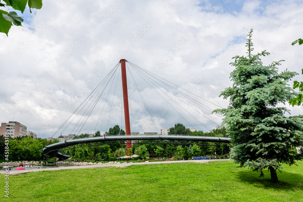 Landscape with the modern red metallic bridge and vivid green grass and ...