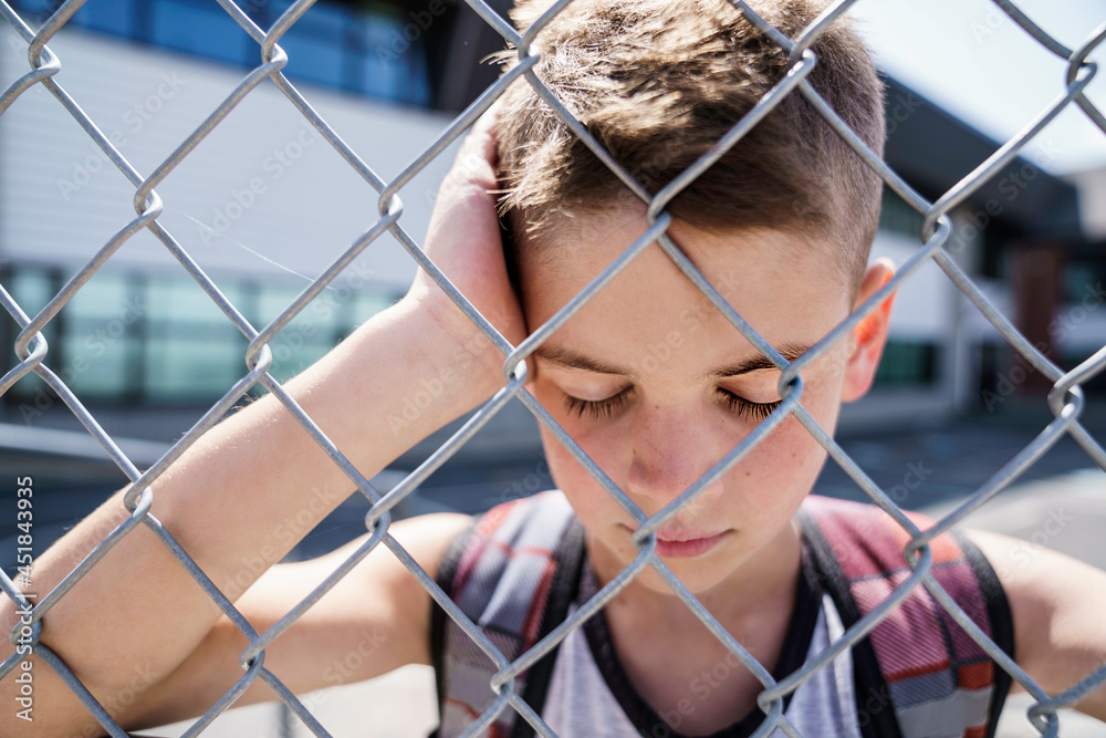 very sad boy bullying in school playground. Stock Photo | Adobe Stock