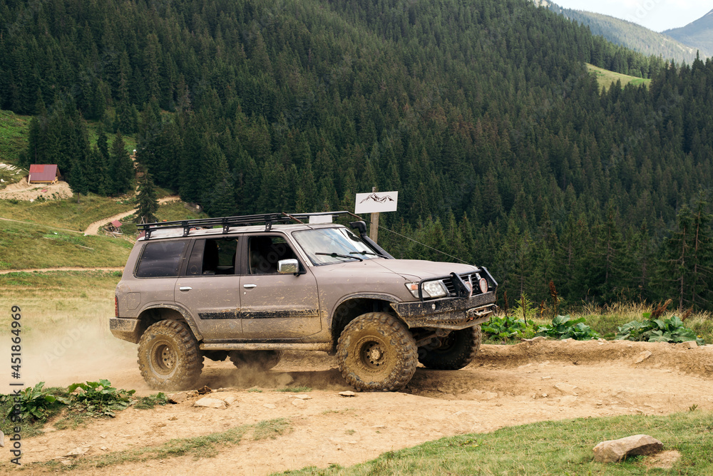 massive 4x4 off-road car on the dirty ground in mountains. Off-road ...
