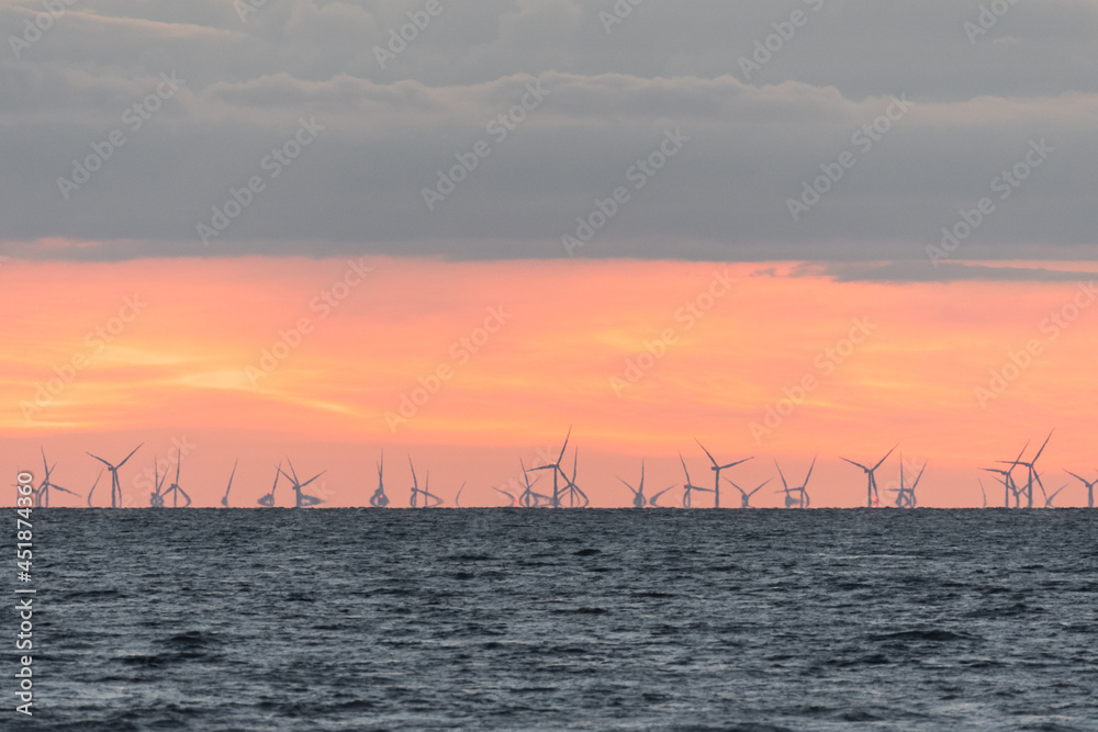 Foto de Wind farm in the Irish Sea at dusk. A mirage effect causes the ...