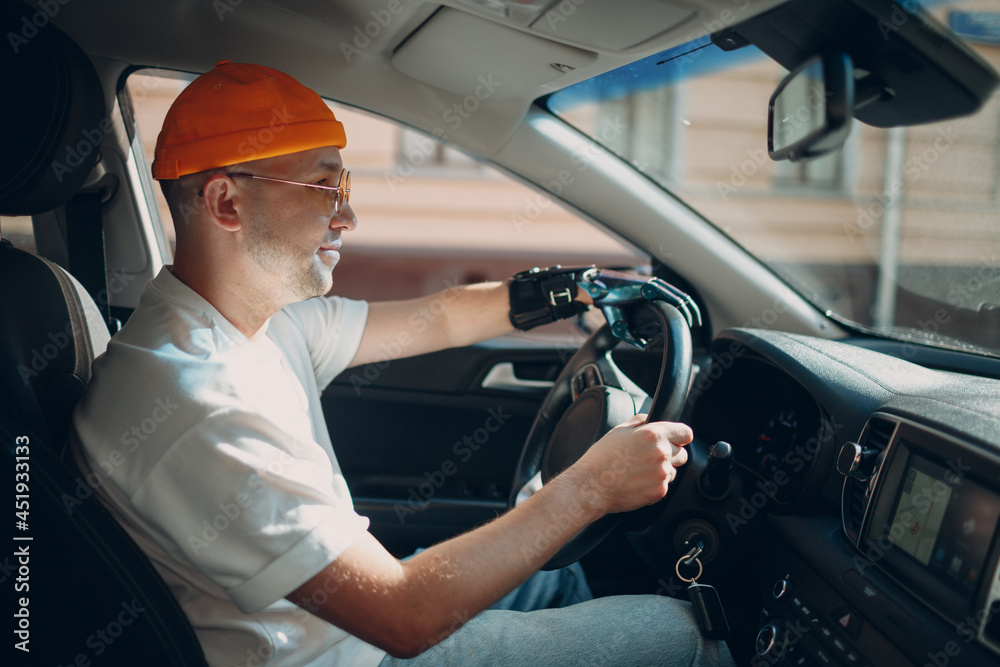 Foto de Young disabled man driver with artificial prosthetic hand ...