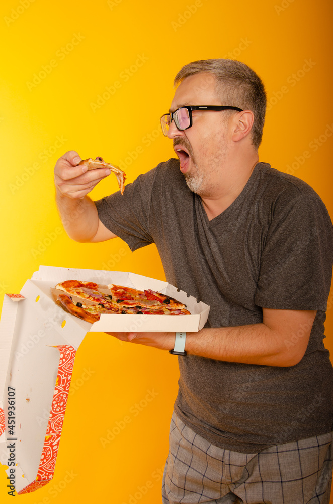 Funny hungry light skinned man, grandpa biting pizza, eating junk food ...