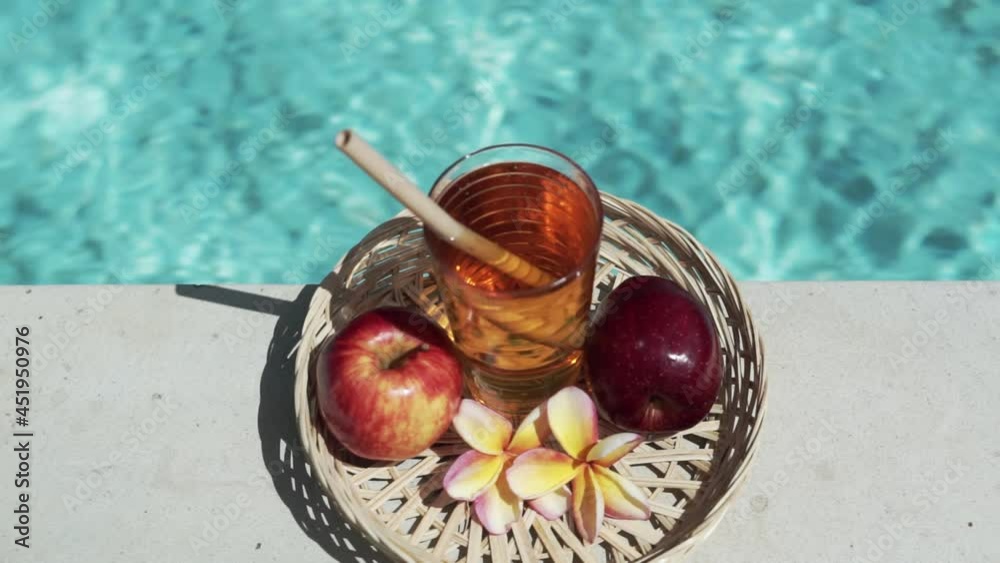 Video footage of glass with apple juice, bamboo straw, red apple ...