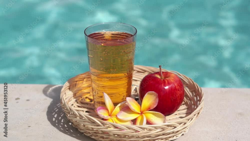 Video footage of glass with apple juice, bamboo straw, red apple ...