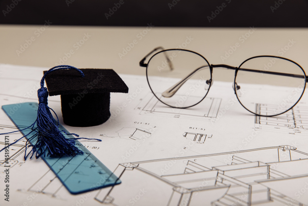 Technical drawings and graduation cap. Engineering education concept ...