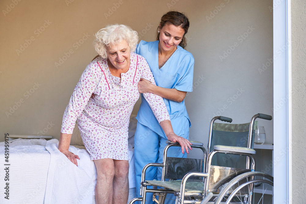 Altenpflegerin hilft Seniorin beim Aufstehen aus dem Bett Stock Photo ...