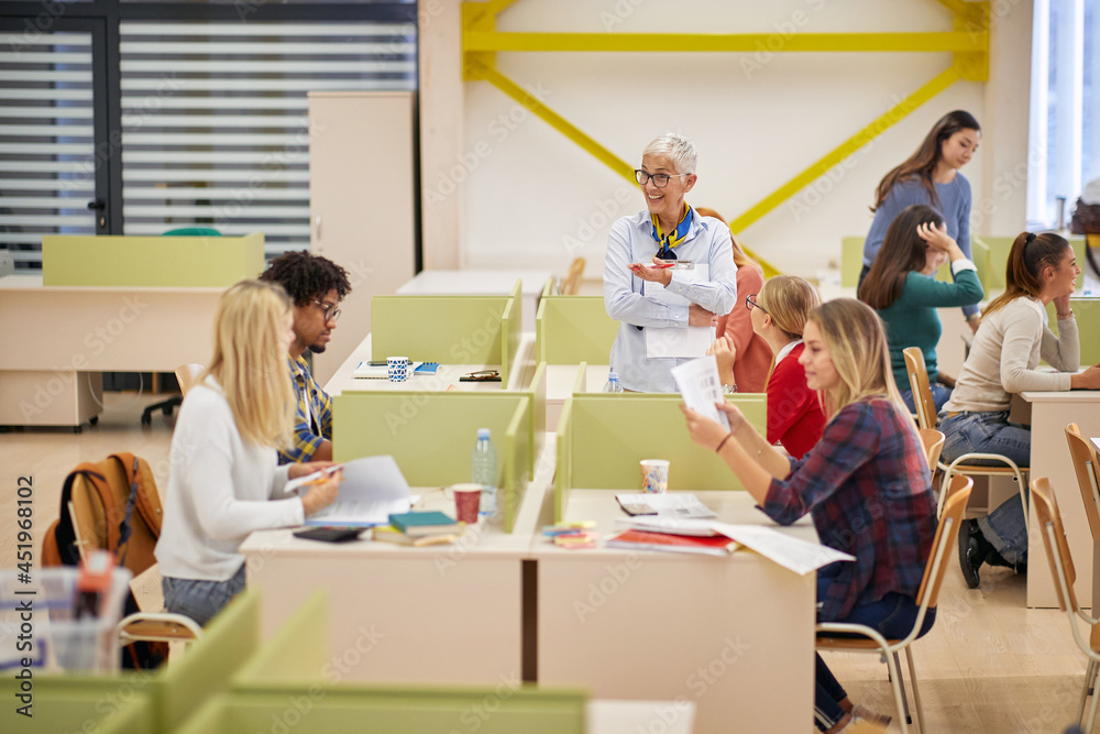 Students learning from a cool female professor. Smart young people ...
