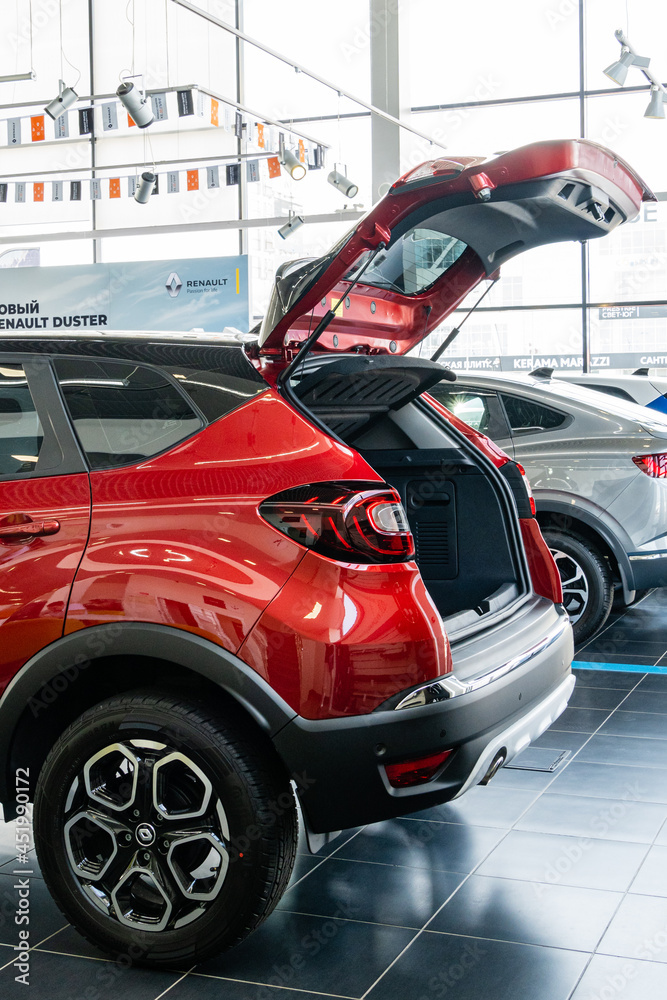 Renault Captur SUV in red in showroom of car dealership.Tailgate is ...