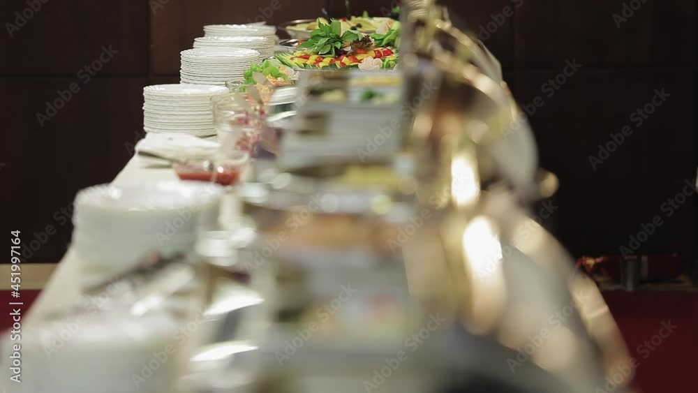 Various food and drinks are laid out on a long table. This is a buffet ...