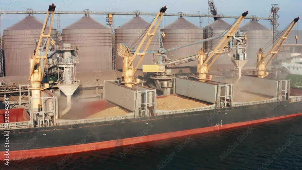 Drone video - loading grain into holds of sea cargo vessel through an ...
