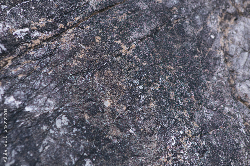 texture of a dark gray stone with white and yellow-orange splashes ...