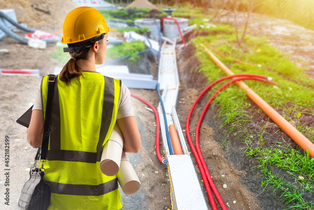 Foto de Sewerage laying before construction. Woman engineer next to ...