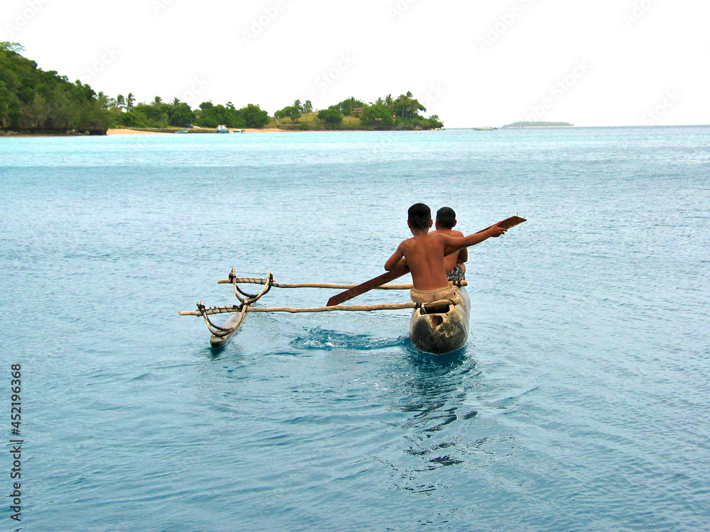Children paddling in a canoe, two young Tongans in a dugout proa. Stock ...