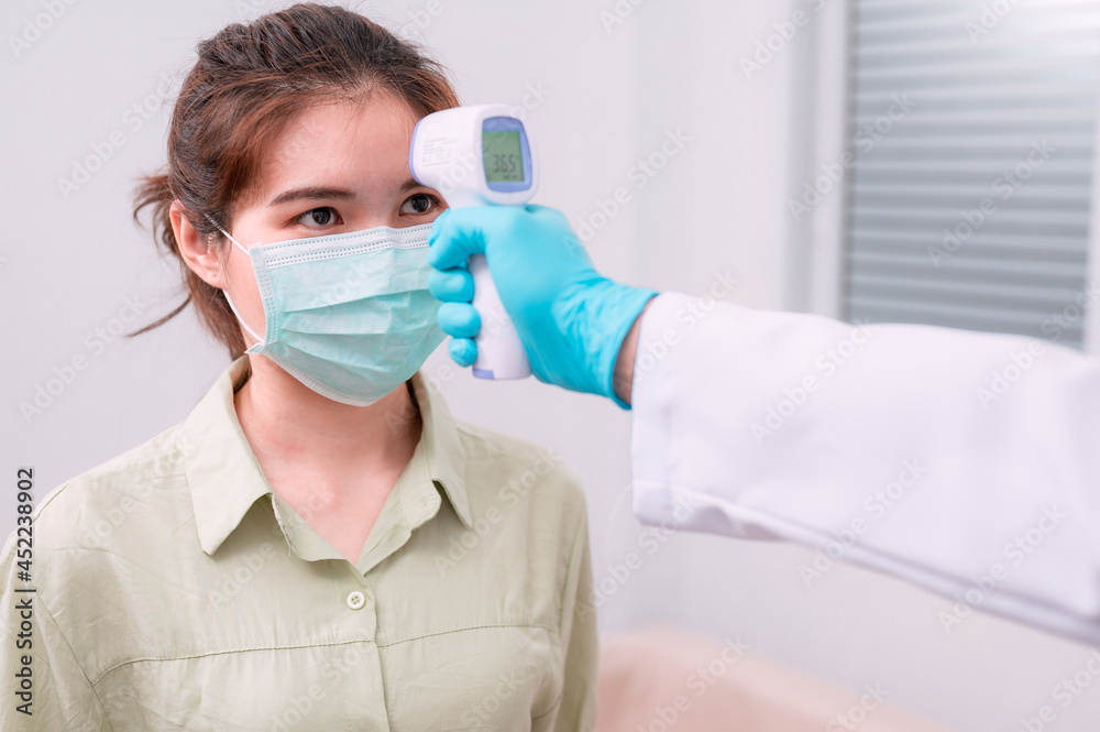 The doctor measures the patient's temperature before receiving the ...