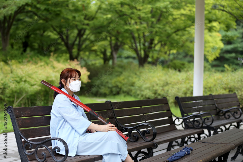Korean woman practicing kendo in a hi-dong kendo pose with a sword ...