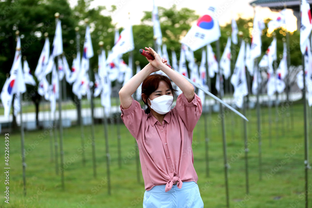 Korean woman practicing kendo in a hi-dong kendo pose with a sword ...